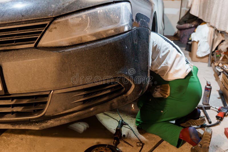 Car Mechanic Working Underneath a Vehicle in a Garage Stock Photo ...
