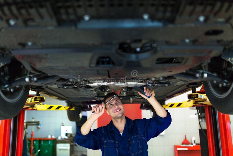 Car Mechanic Working on the Underside of a Car Stock Photo - Image of ...