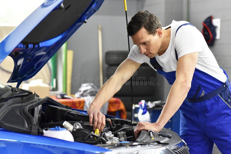 Car Mechanic in a Workshop Repairing a Vehicle Stock Photo - Image of ...