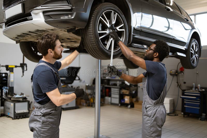 Car Mechanics Working on Vehicle Maintenance in Modern Garage Stock ...