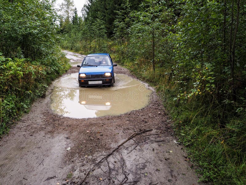 The Car Crosses a Puddle. the Car in the Rain Blurred the Road. Stock ...