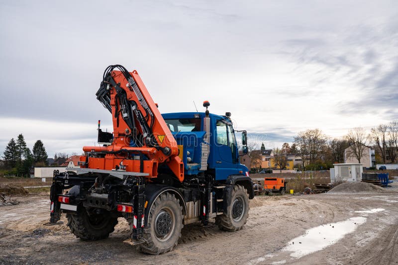 A Car with an Orange Manipulator Crane is Standing on a Construction ...