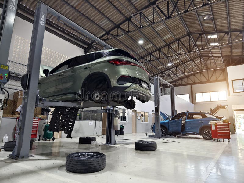 A Car is Raised Up Using a Lift Inside a Service for Maintenance Stock ...