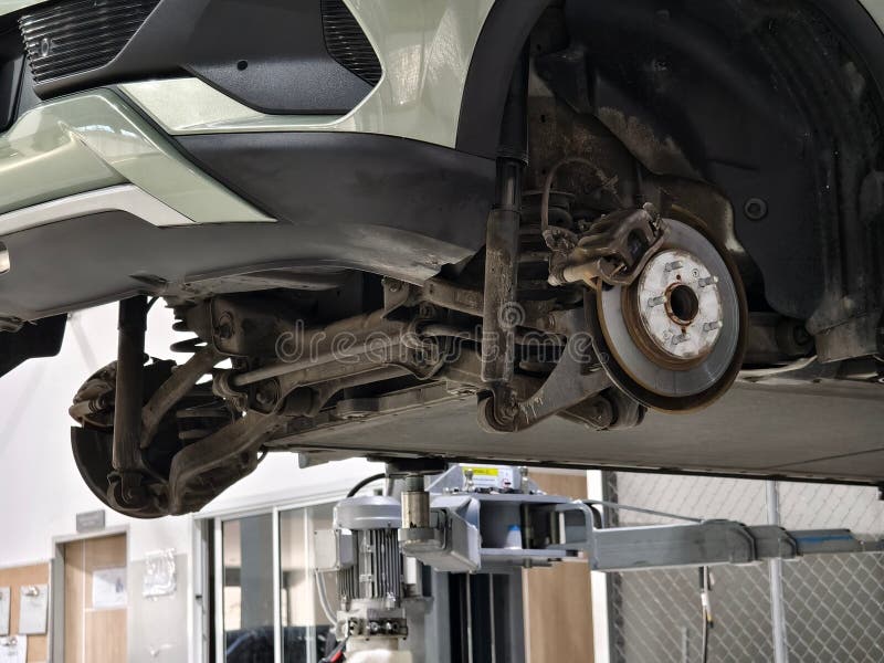 A Car is Raised Up Using a Lift Inside a Service for Maintenance Stock ...