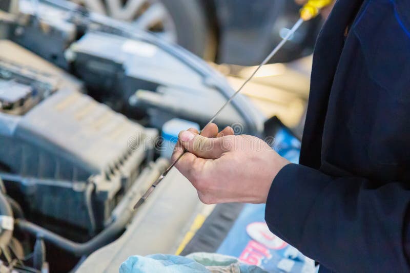 Car Repair Service. Mechanic Checking the Oil Level with Dipstick in ...
