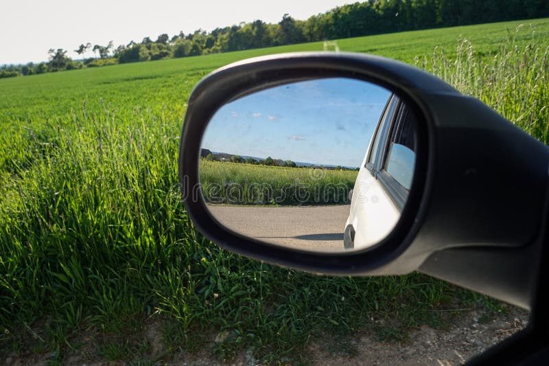 A Car S Rear View Mirror Shows a Field with a Blue Sky Stock Photo ...