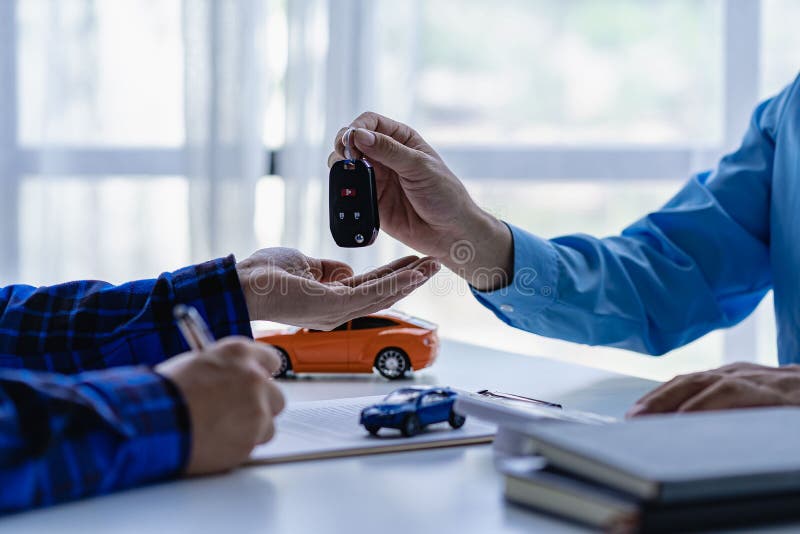 Car Salesman Handing Keys To New Car To Young Businessman Client after ... Car Salesman Handing Keys To New Car To Young Businessman Client after ...