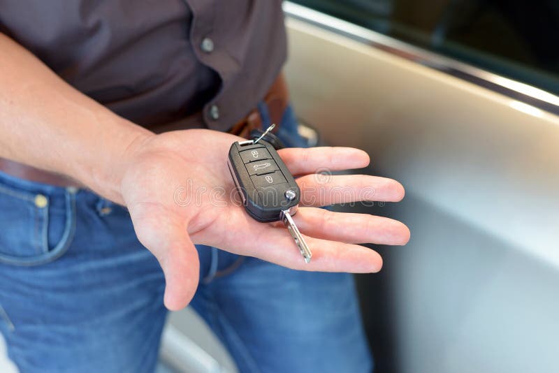 Car Salesman Hands Over the Car Key in the Car Dealership To Customers ...