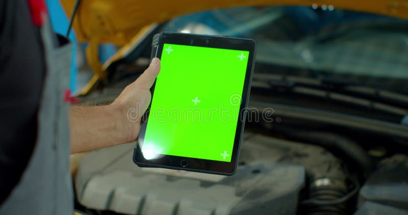 Car Service Manager or Mechanic Uses a Tablet Computer with a Green ...
