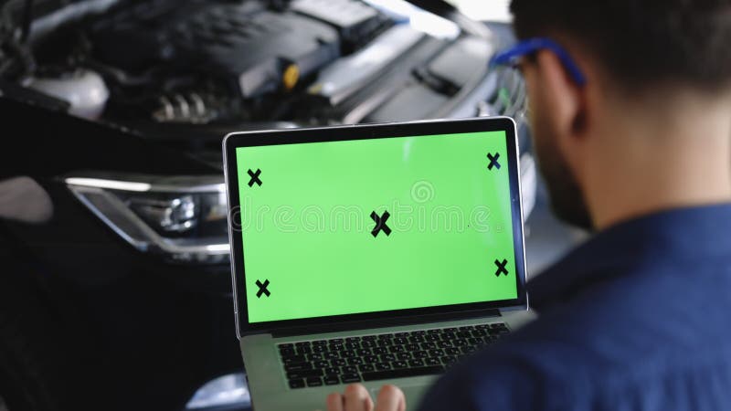 Car Service Mechanic Uses Laptop Computer with Green Screen Mock Up ...