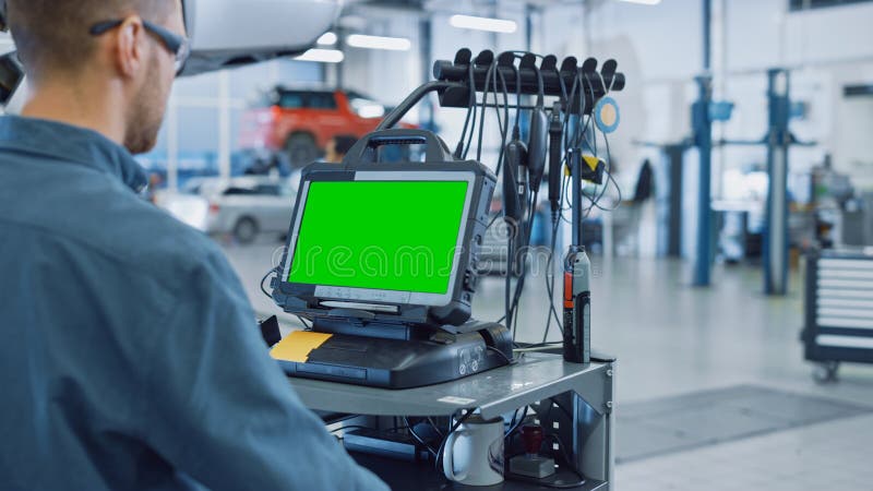 Car Service Mechanic is Running a Diagnostics Software on an Advanced ...