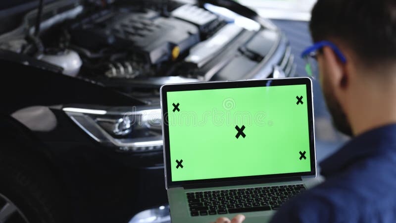 Car Service Mechanic Uses Laptop Computer with Green Screen Mock Up ...
