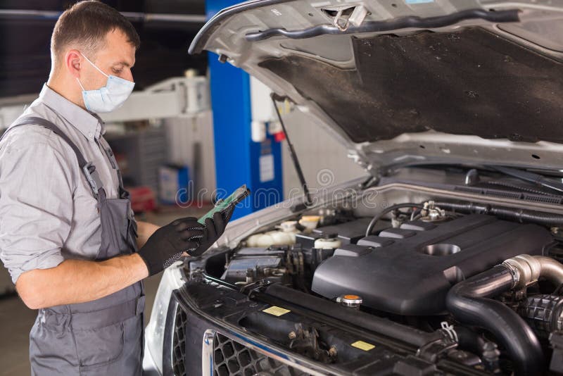 Car Service Worker Carries Out Diagnostics and Car Repairs in the Room ...