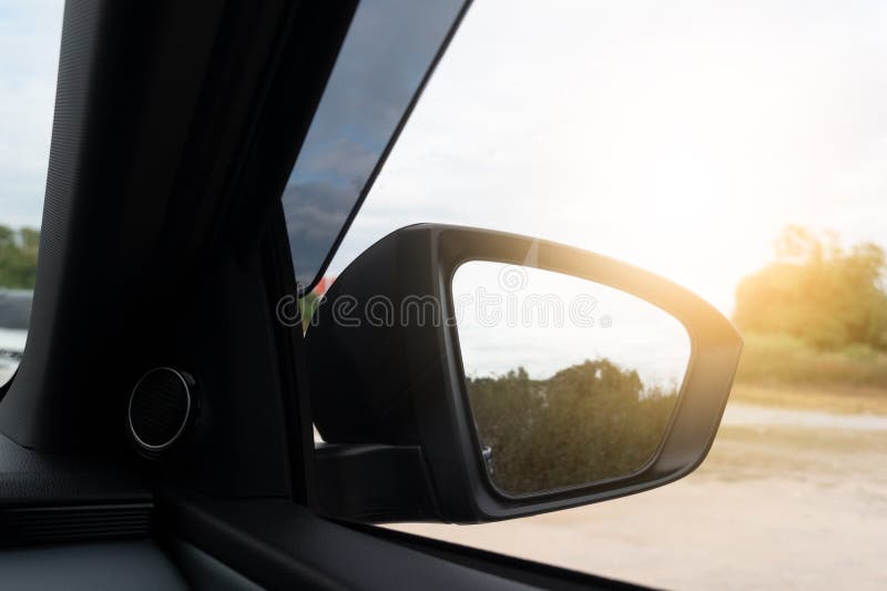 Car Side View Mirror Reflects a Blurred Landscape and Bright Sunlight ...
