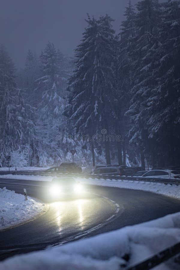 A Car Drives on a Snowy Road through the Forest at Night Stock Image ...