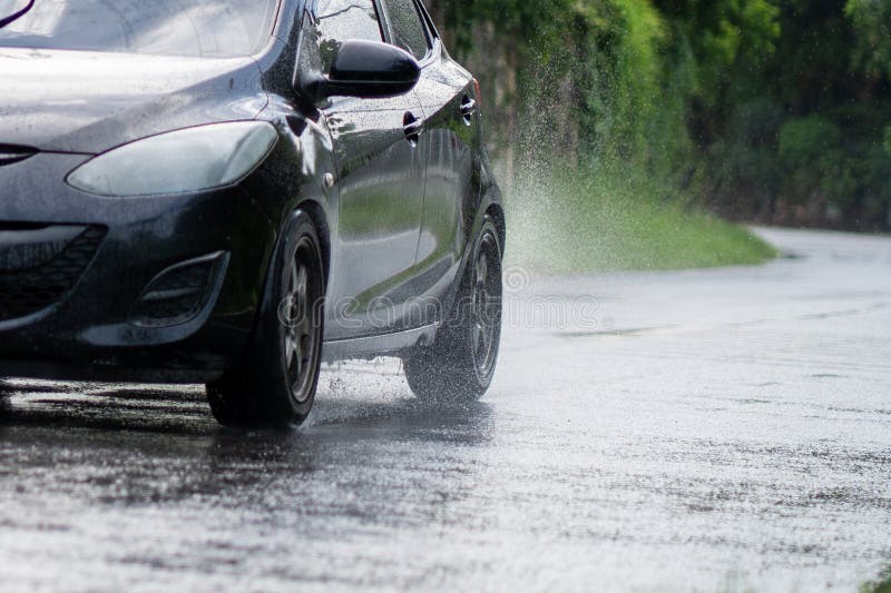 Car Splashes through Large Puddle on Flooded Street. Motion Car Stock ...