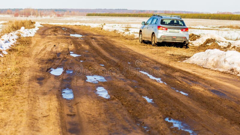 A Car is Standing on the Side of the Road in the Spring Thaw on a ...