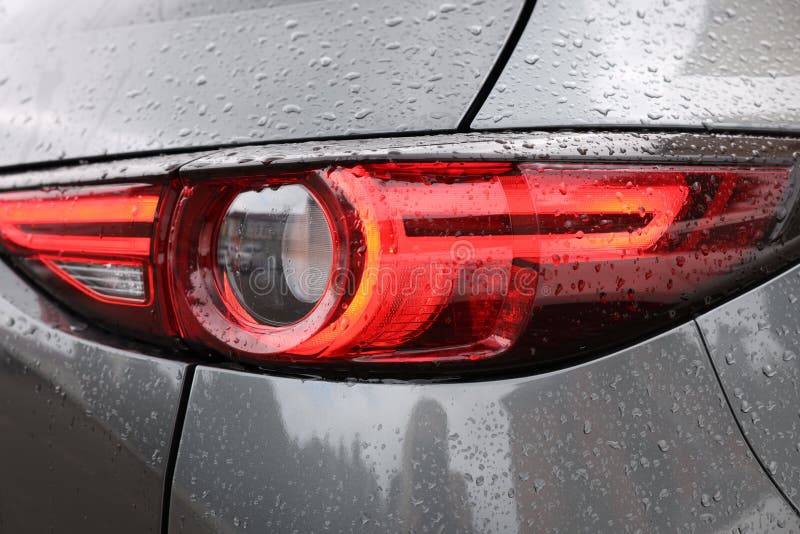 Car with Switched on Tail Light in Drops of Water, Closeup Stock Photo ...