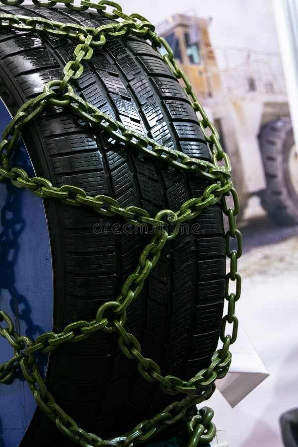 A Car Tire with Green Snow Chains. the Tire is Black with a Clear Tread ...