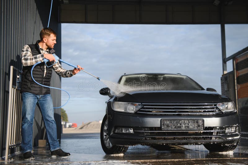 Car Wash. Man Washes Car with Water from High Pressure Washer Stock ...