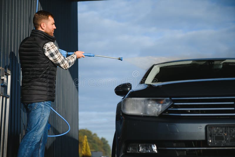 Car Wash. Man Washes Car with Water from High Pressure Washer Stock ...