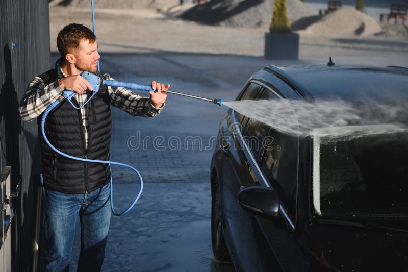 Car Wash. Man Washes Car with Water from High Pressure Washer Stock ...