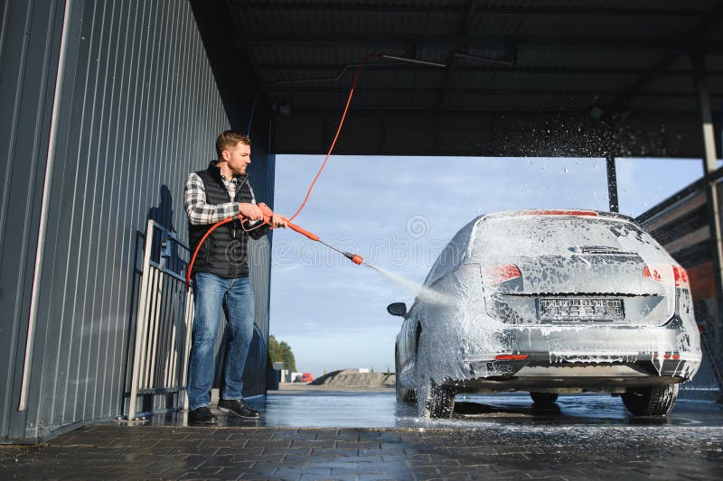 Car is Washed at a Professional Car Wash. Man Washes a Car with Foam ...