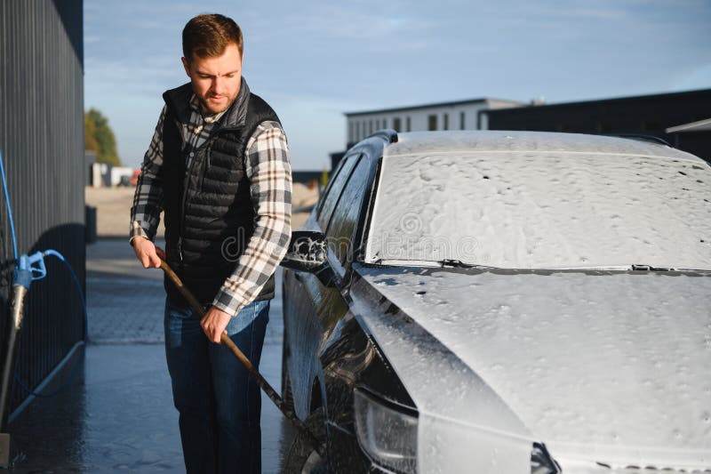 Car is Washed at a Professional Car Wash. Man Washes a Car with Foam ...
