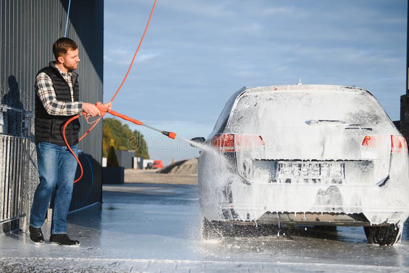 Car is Washed at a Professional Car Wash. Man Washes a Car with Foam ...
