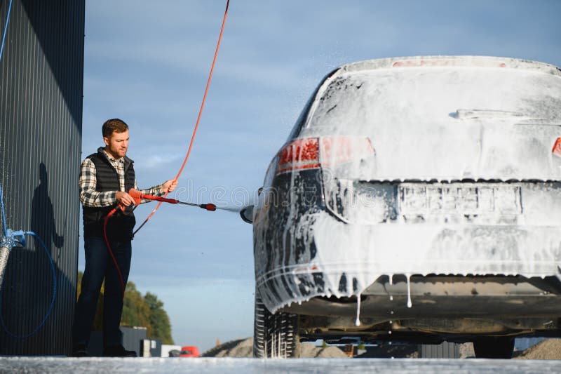 Car is Washed at a Professional Car Wash. Man Washes a Car with Foam ...