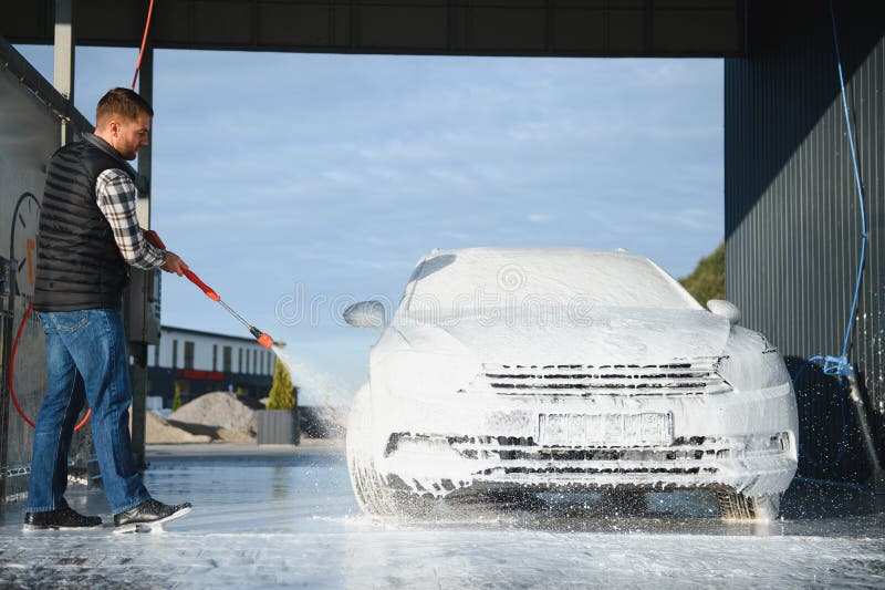 Car is Washed at a Professional Car Wash. Man Washes a Car with Foam ...