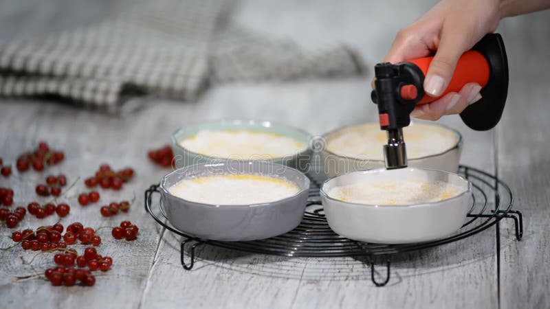 Caramelizing Sugar on the Top of Creme Brulee Using Gas Torch. Stock ...