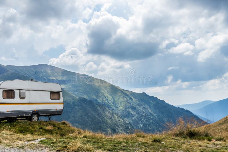 Caravan Parked on the Ledge of a Mountain Road with Mountains in the ...