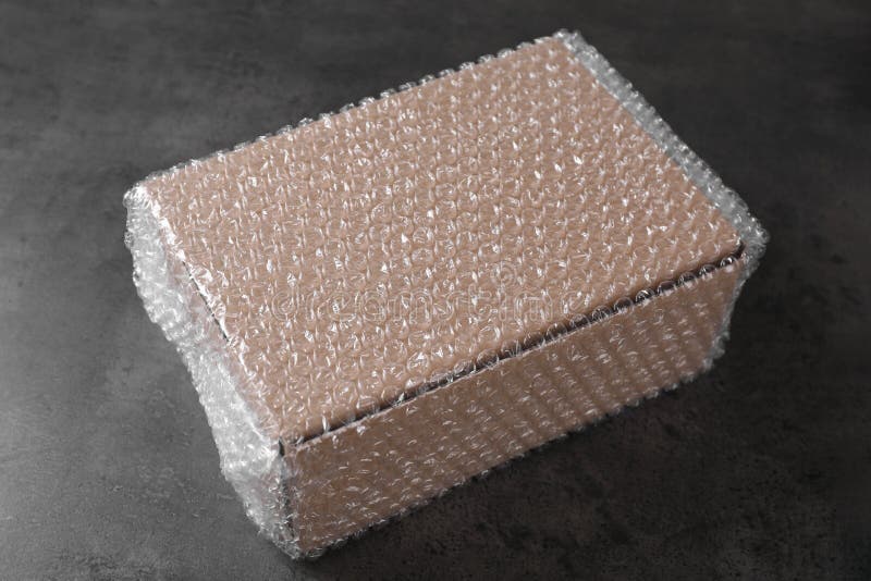 Cardboard Box Covered with Bubble Wrap on Dark Grey Table Stock Photo ...