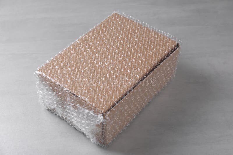Cardboard Box Covered with Bubble Wrap on Light Grey Table Stock Image ...