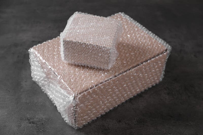 Cardboard Boxes Covered with Bubble Wrap on Dark Grey Table Stock Image ...