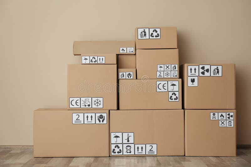 Cardboard Boxes with Different Packaging Symbols on Floor Near Beige ...