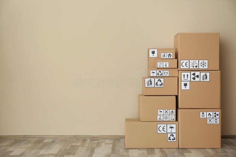 Cardboard Boxes with Different Packaging Symbols on Floor Near Beige ...