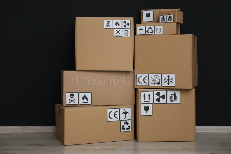 Cardboard Boxes with Different Packaging Symbols on Floor Near Black ...