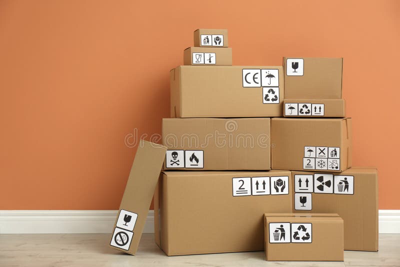 Cardboard Boxes with Different Packaging Symbols on Floor Near Orange ...