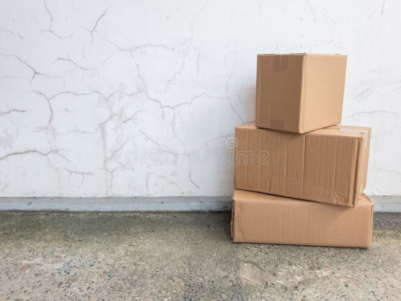 Cardboard Boxes Stacked Against a Textured Wall, Ready for Shipping and ...