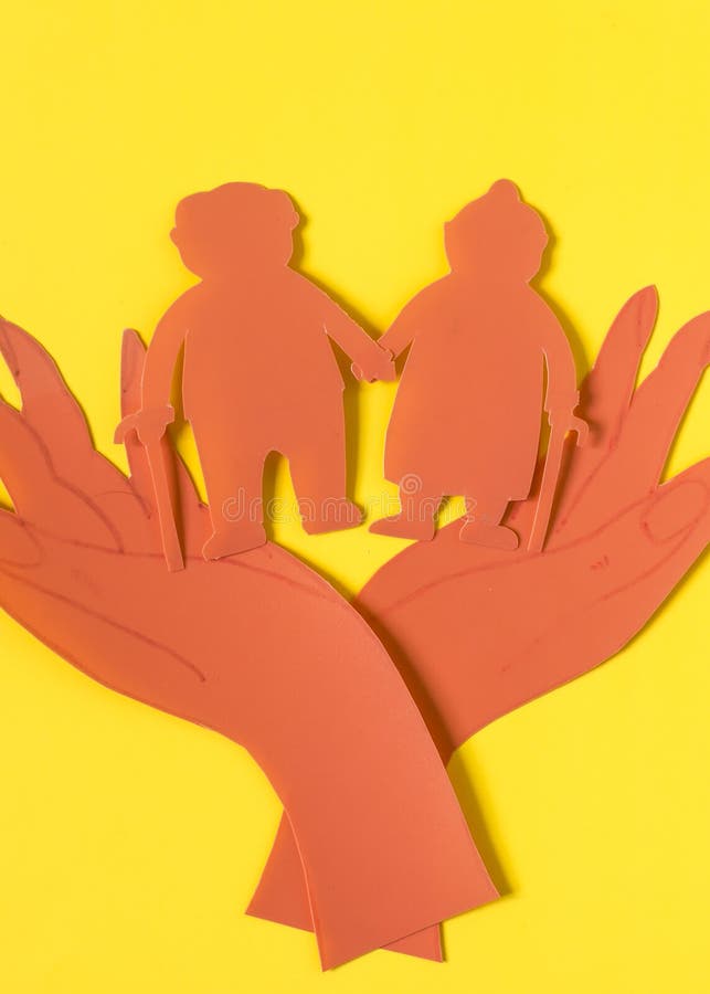Cardboard Figures are Held Open Palms by Two Elderly People. the ...