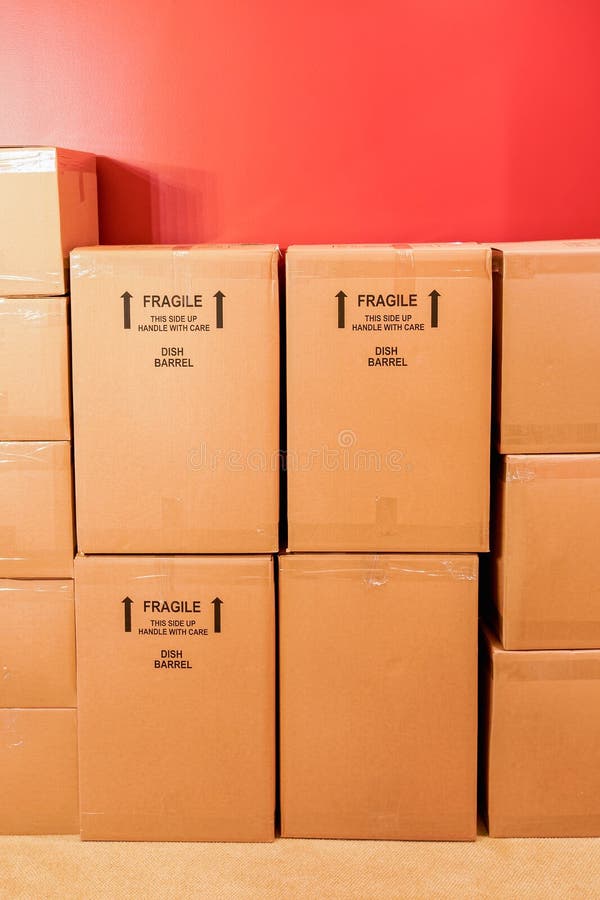 Cardboard Moving Boxes Stacked Up Against a Red Wall Stock Photo ...