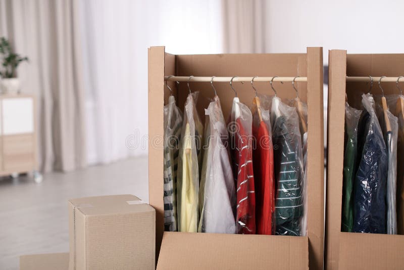 Cardboard Wardrobe Boxes with Clothes on Hangers Indoors. Stock Photo ...