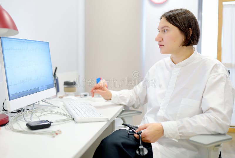 A Cardiologist during Appointment of Patient. Doctor Shows EKG on the ...