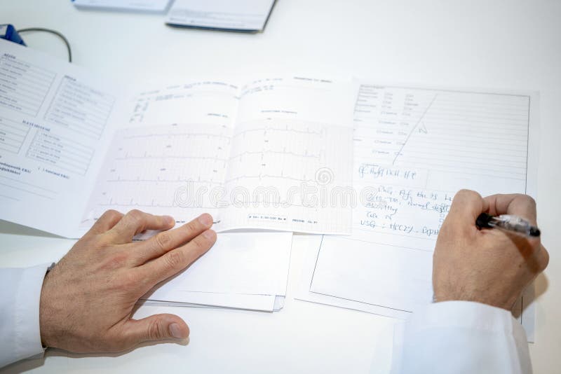 Cardiologist Doctor Looking At Electrocardiograph Ekg Paper Filling