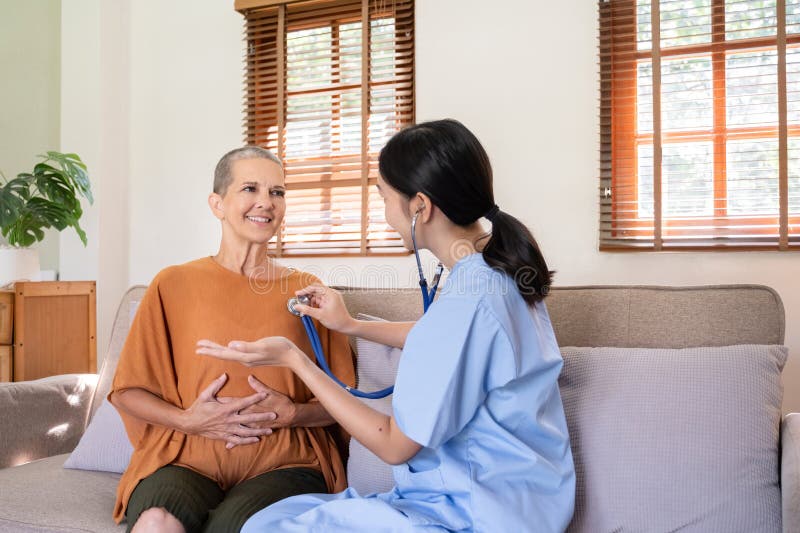Caregiver Assisting Elderly Woman With Health Checkup At Home