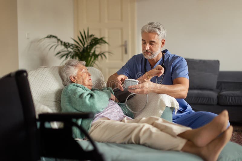 Caregiver Doing Regular Check-up of Senior Woman in Her Home. Stock ...