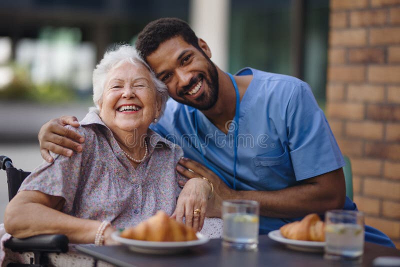 Caregiver Having Breakfast with His Client at Cafe. Stock Image - Image ...