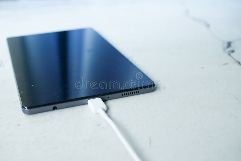 Cargando Una Tableta Digital Con Un Cable Sobre Fondo Blanco Foto de ...